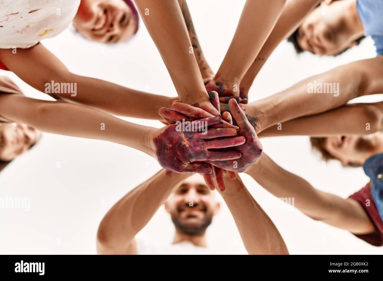 Group of young friends with hands together Stock Photo - Alamy