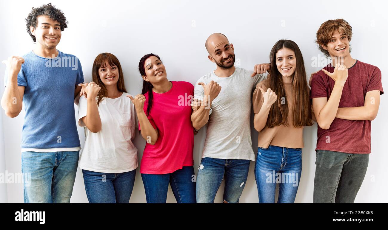 Group of young friends standing together over isolated background ...