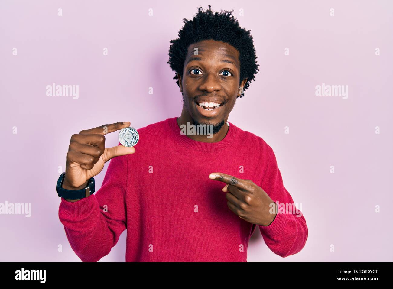 Young african american man holding virtual currency ethereum coin ...