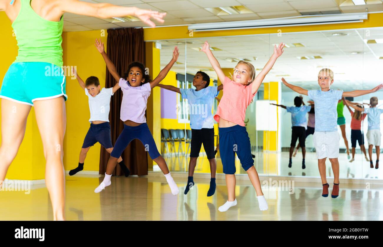 sportive children with teacher jumping together Stock Photo - Alamy