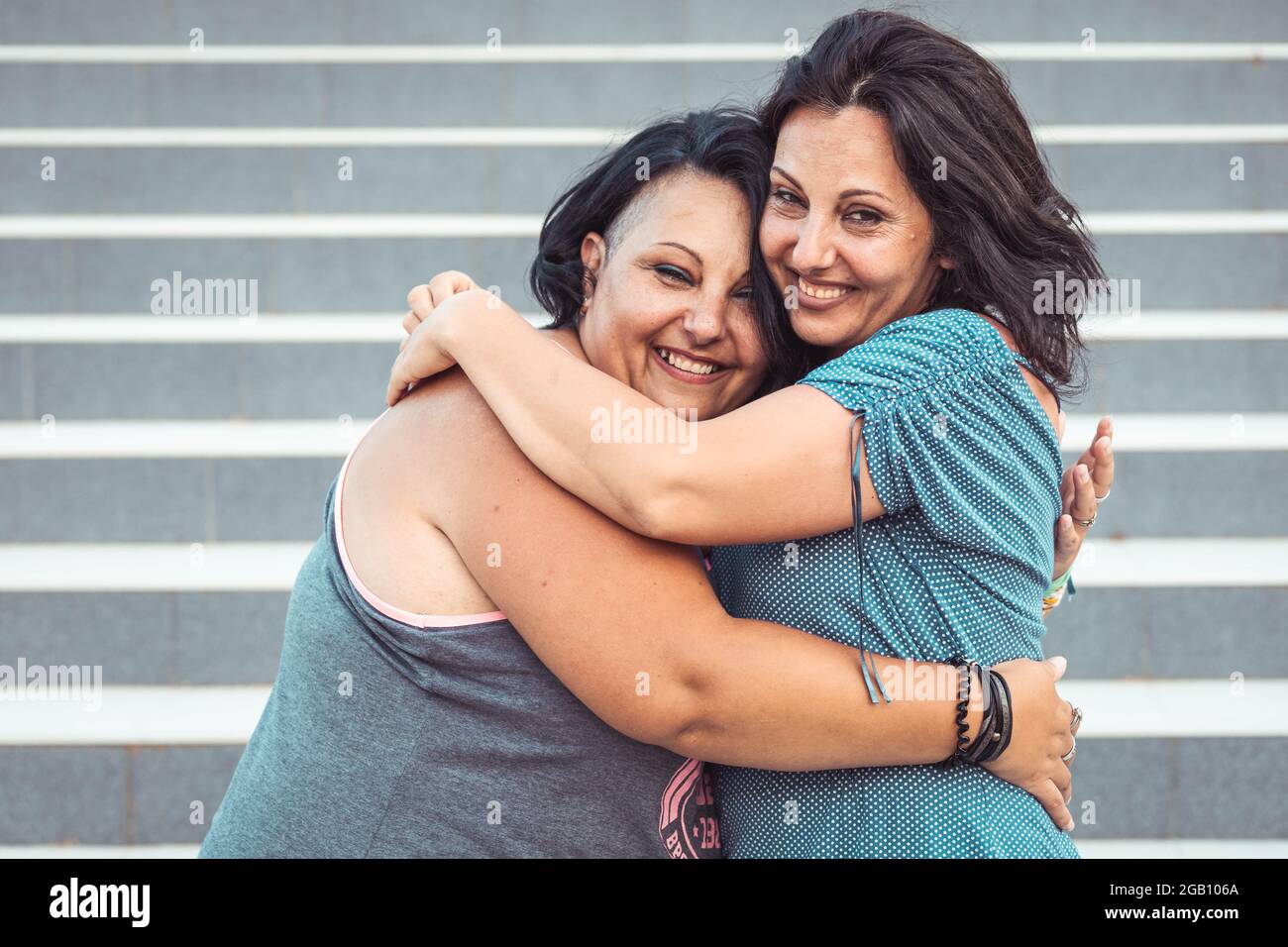 Two adult twin sisters hugging. Different styles Stock Photo - Alamy