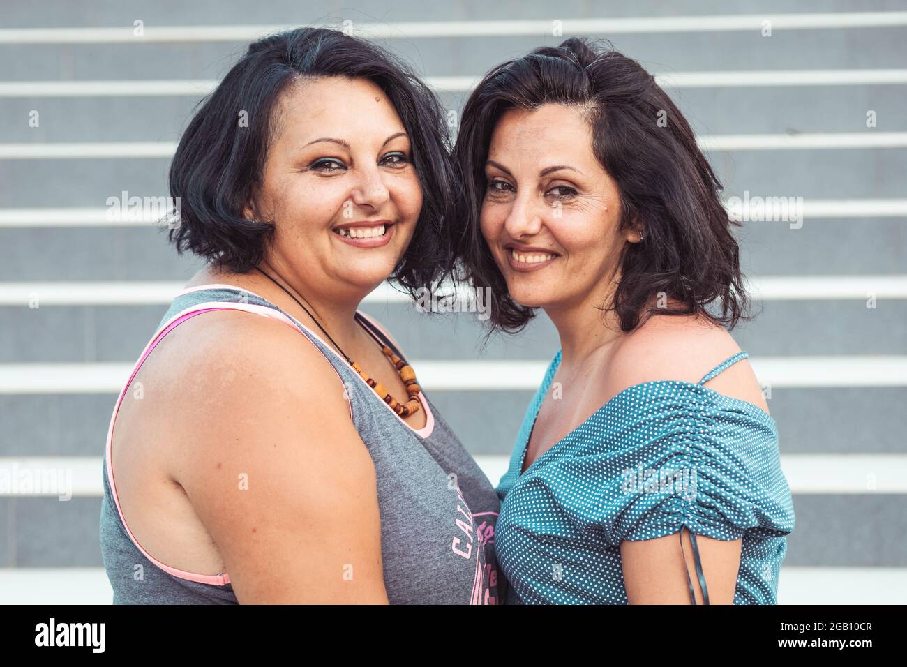 Portrait of two adult brunette twin sisters. Different styles Stock ...