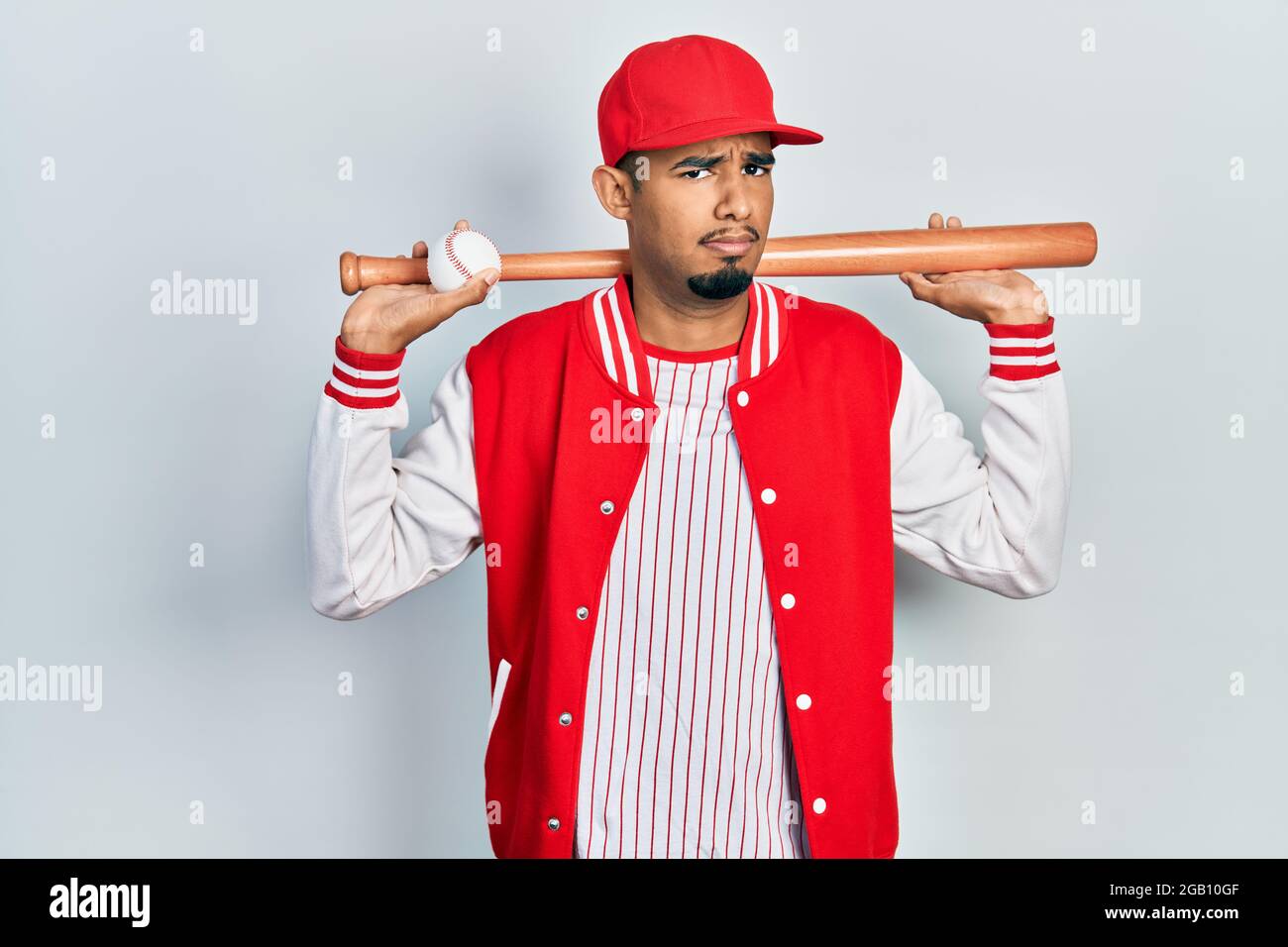 Young african american man playing baseball holding bat and ball ...