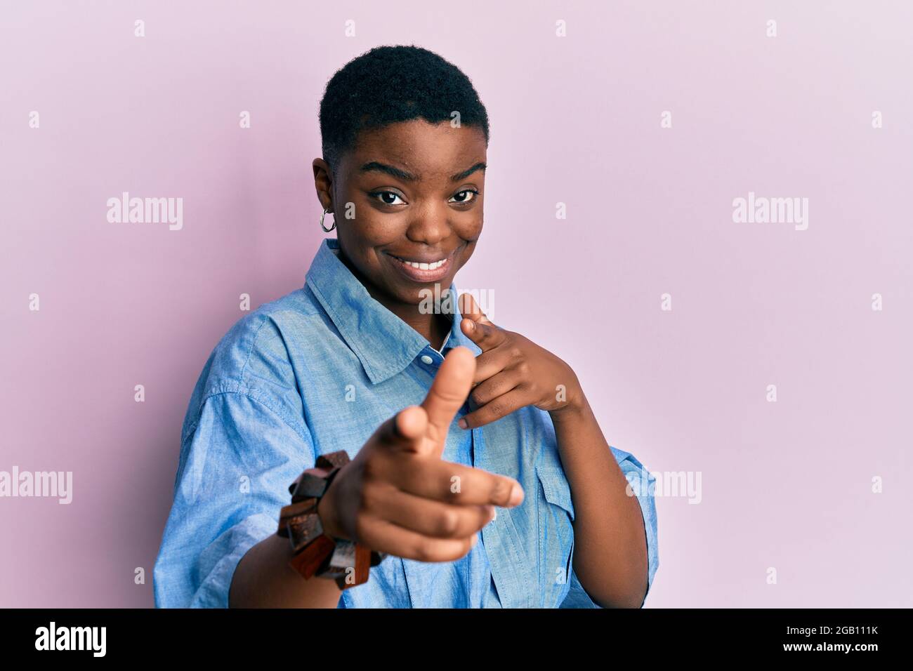 Young african american woman wearing casual clothes pointing fingers to ...