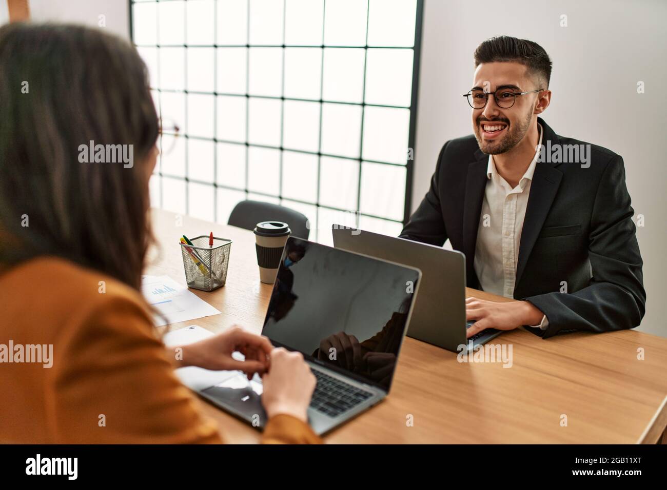 Two hispanic business workers smiling happy working at the office Stock ...