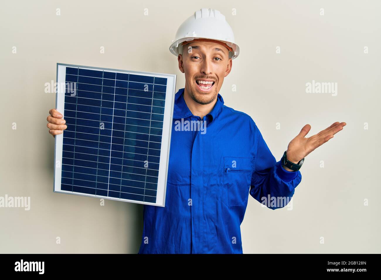 Bald engineer man with beard holding photovoltaic solar panel ...