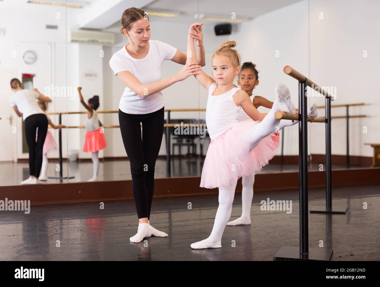 Girls practicing elements on ballet barre Stock Photo - Alamy