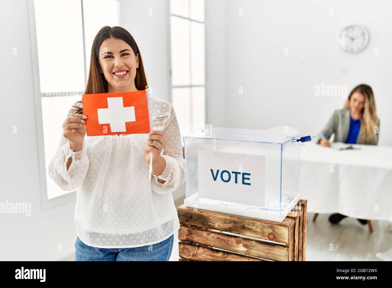 Young swiss voter woman smiling happy holding switzerland flag at ...