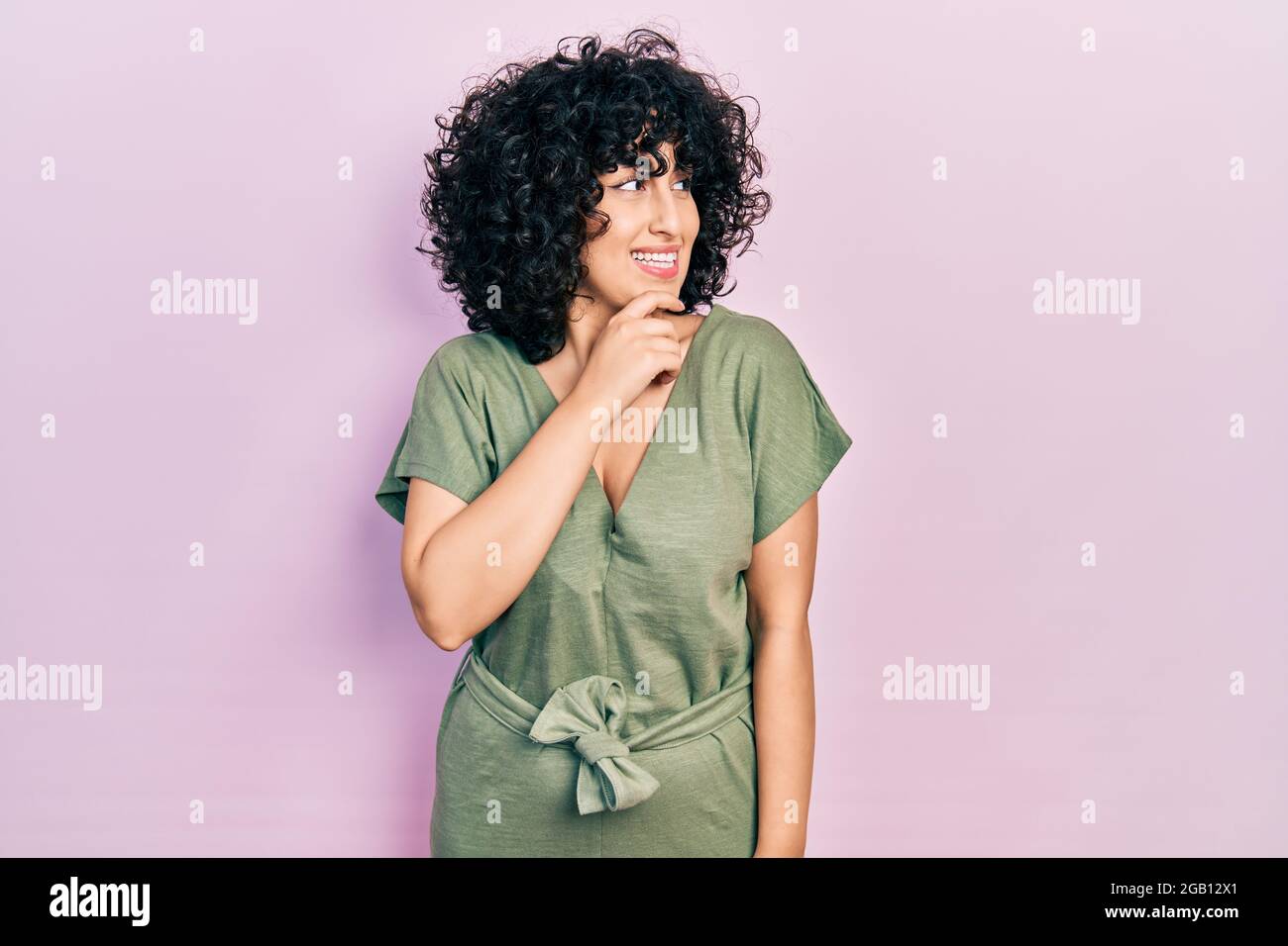 Young middle east woman wearing casual clothes with hand on chin ...