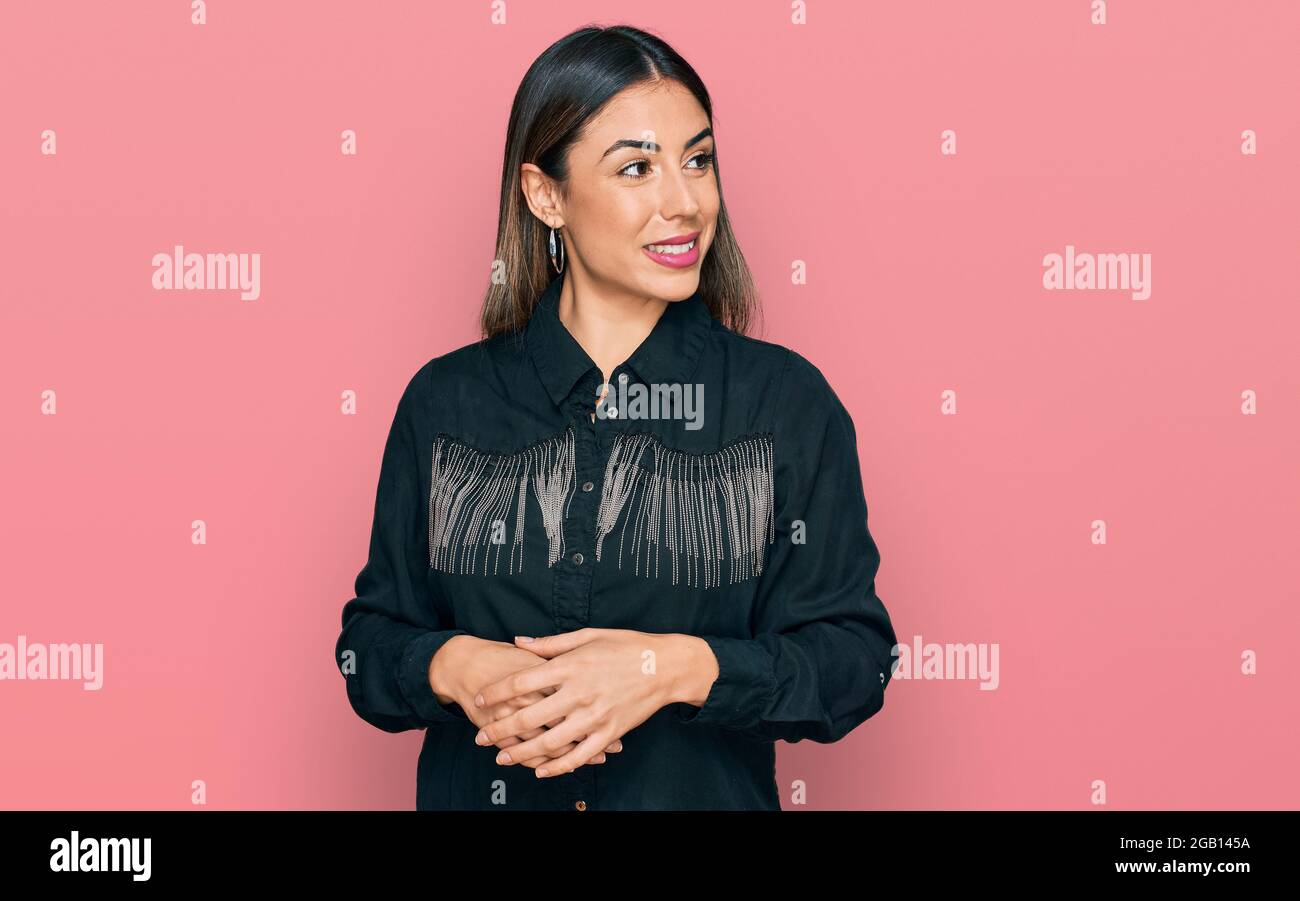 Young hispanic woman wearing casual clothes looking away to side with ...