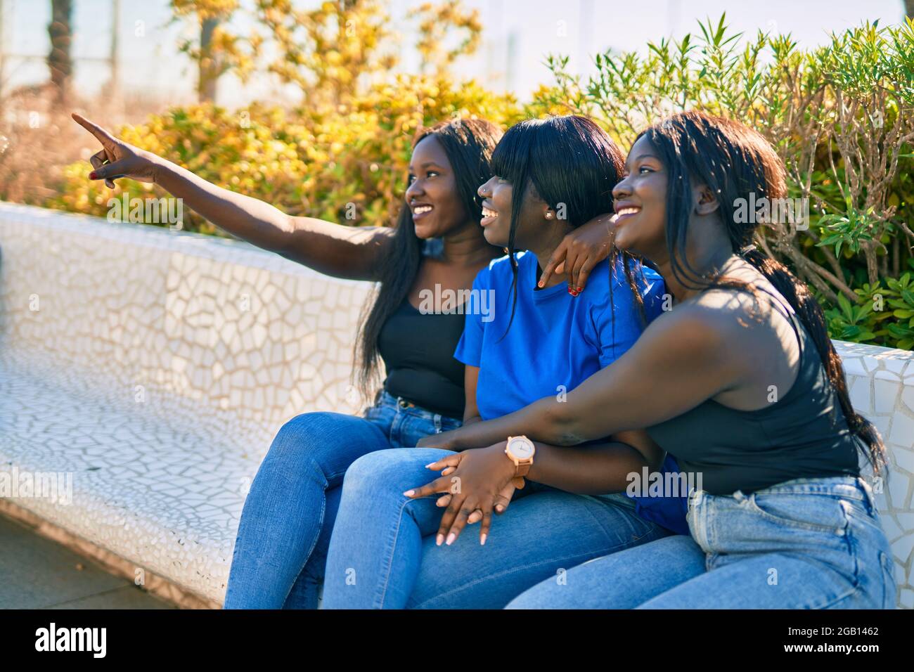 Three african american friends pointing with finger sitting on the ...