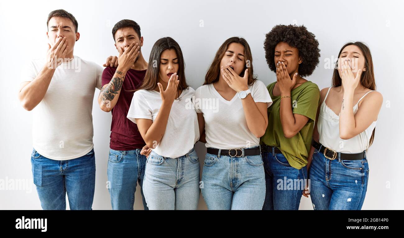 Group of young friends standing together over isolated background bored ...