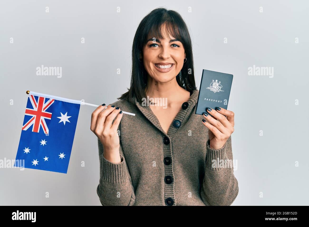 Young hispanic woman holding australian flag and passport smiling with ...