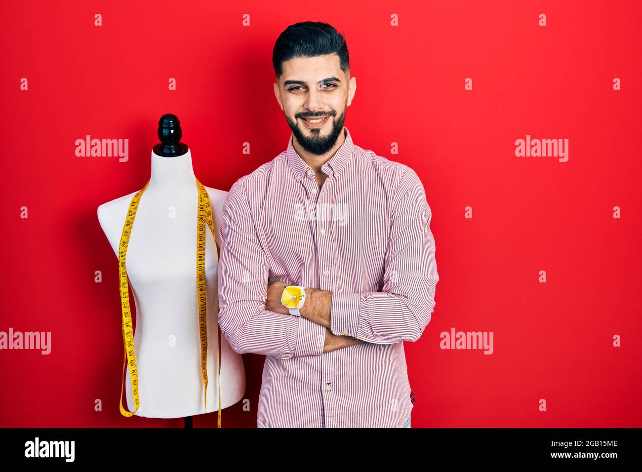 Handsome tailor man with beard with arms crossed gesture smiling and ...