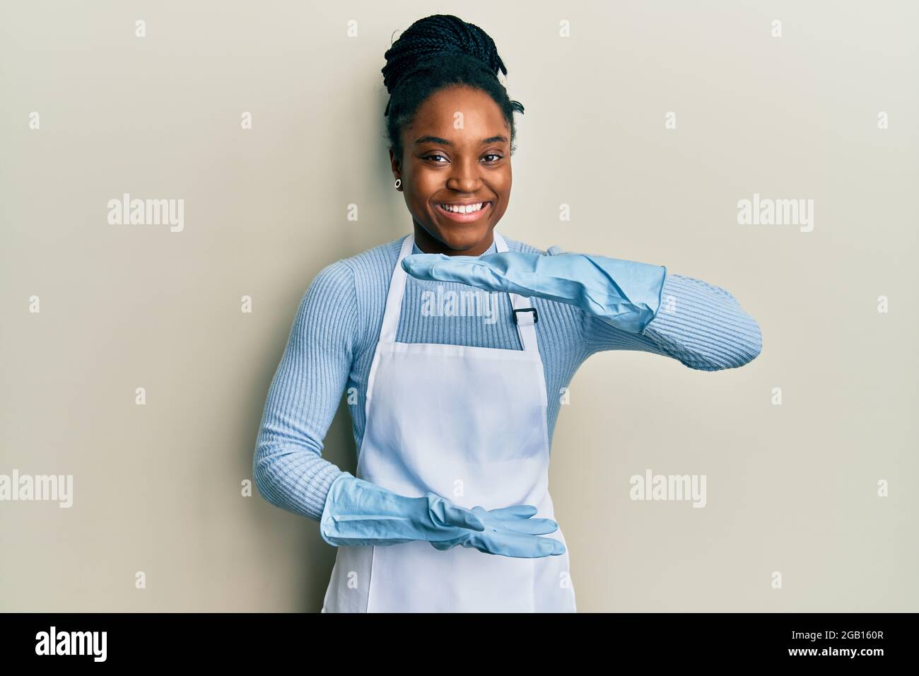 African american woman with braided hair wearing cleaner apron and ...