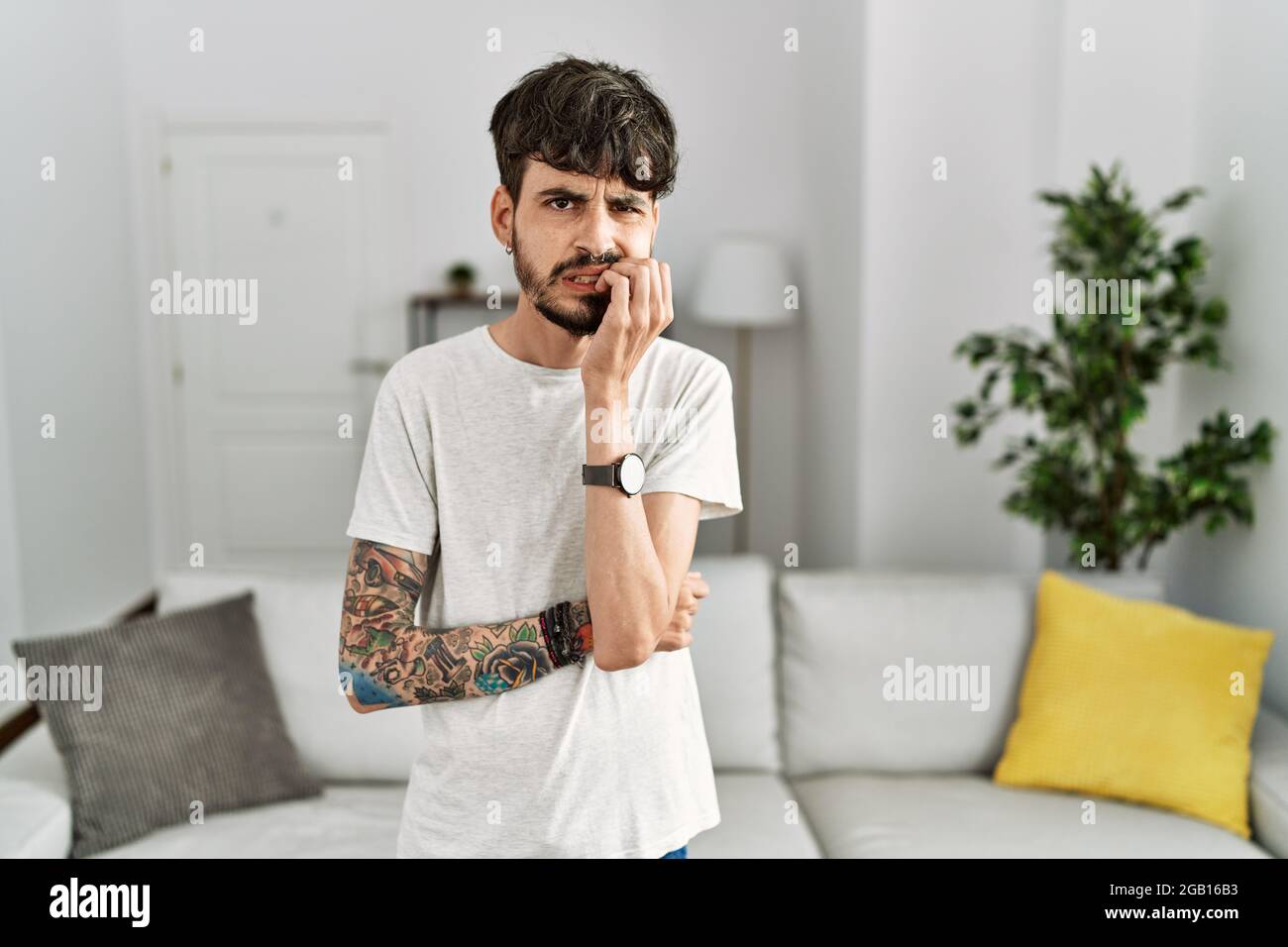 Hispanic man with beard at the living room at home looking stressed and ...