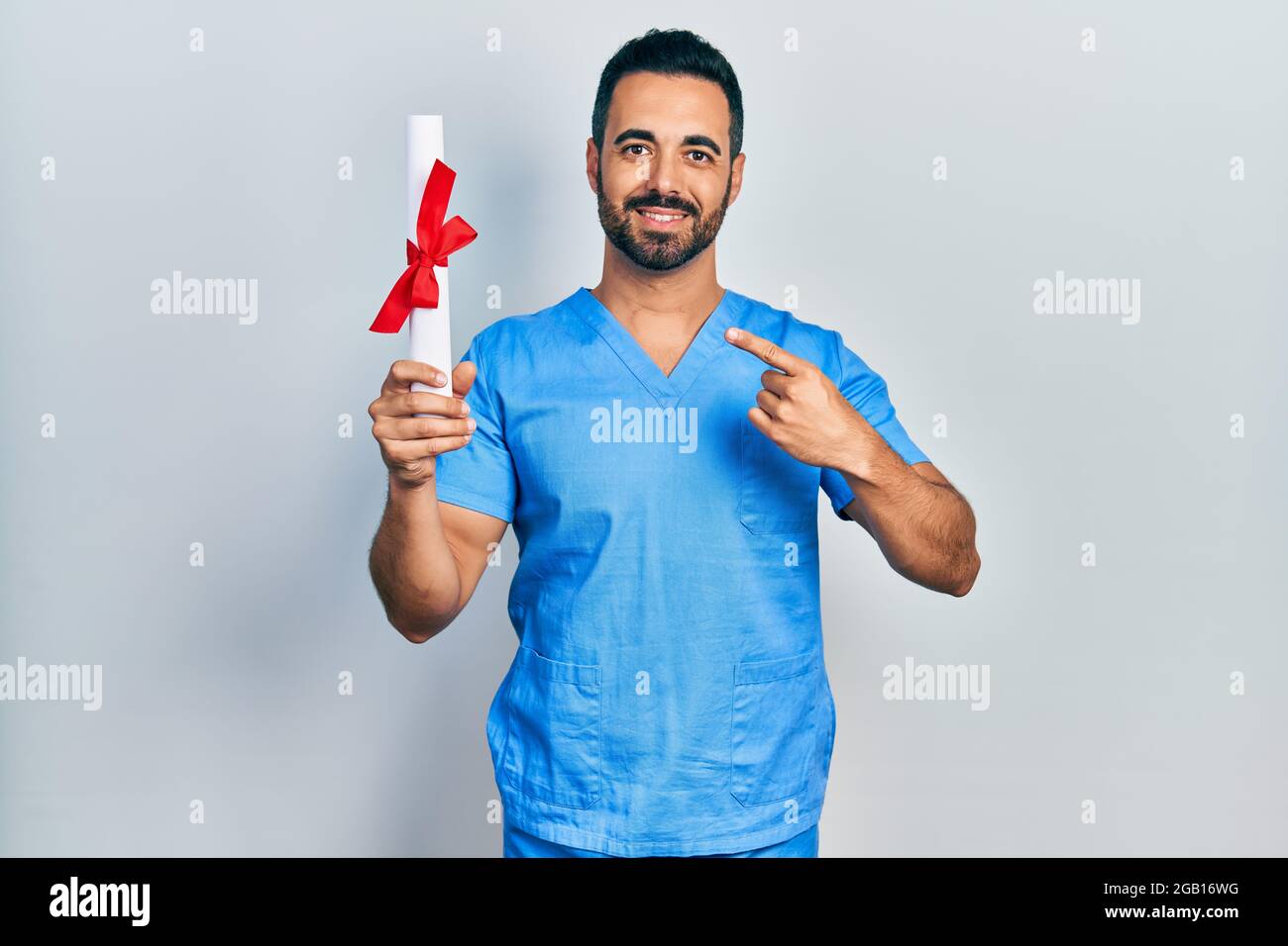 Handsome hispanic man with beard wearing blue male nurse uniform ...