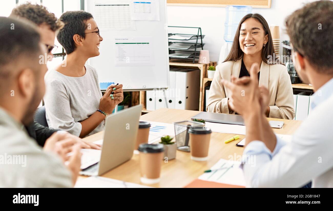 Group of business workers smiling and clapping to partner at the office ...