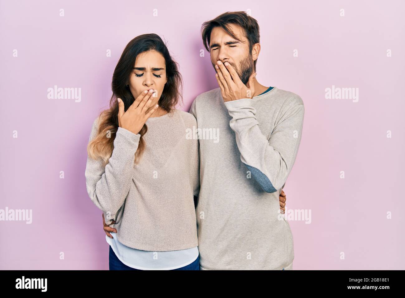 Young hispanic couple wearing casual clothes bored yawning tired ...