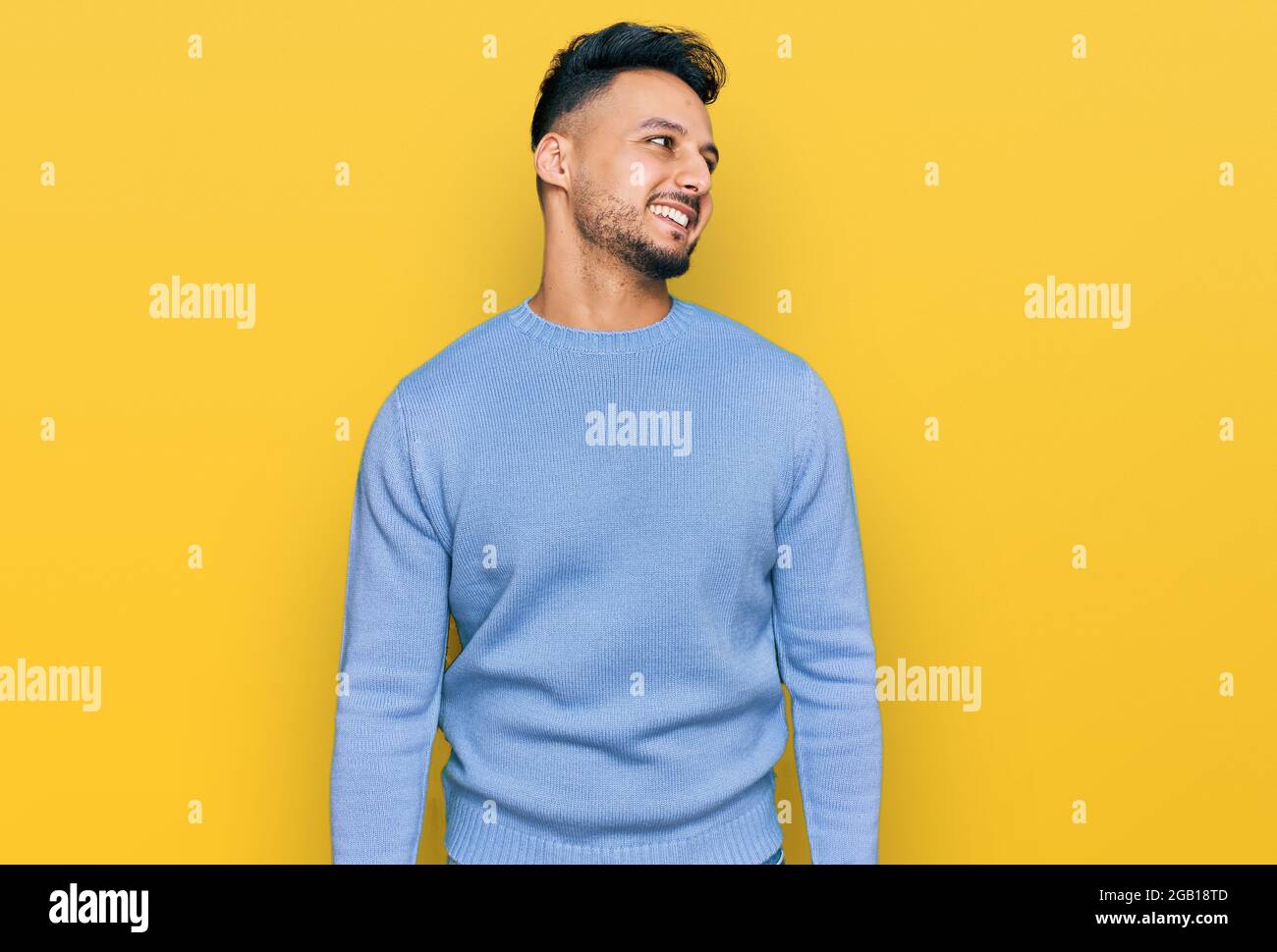 Young arab man wearing casual clothes looking away to side with smile ...
