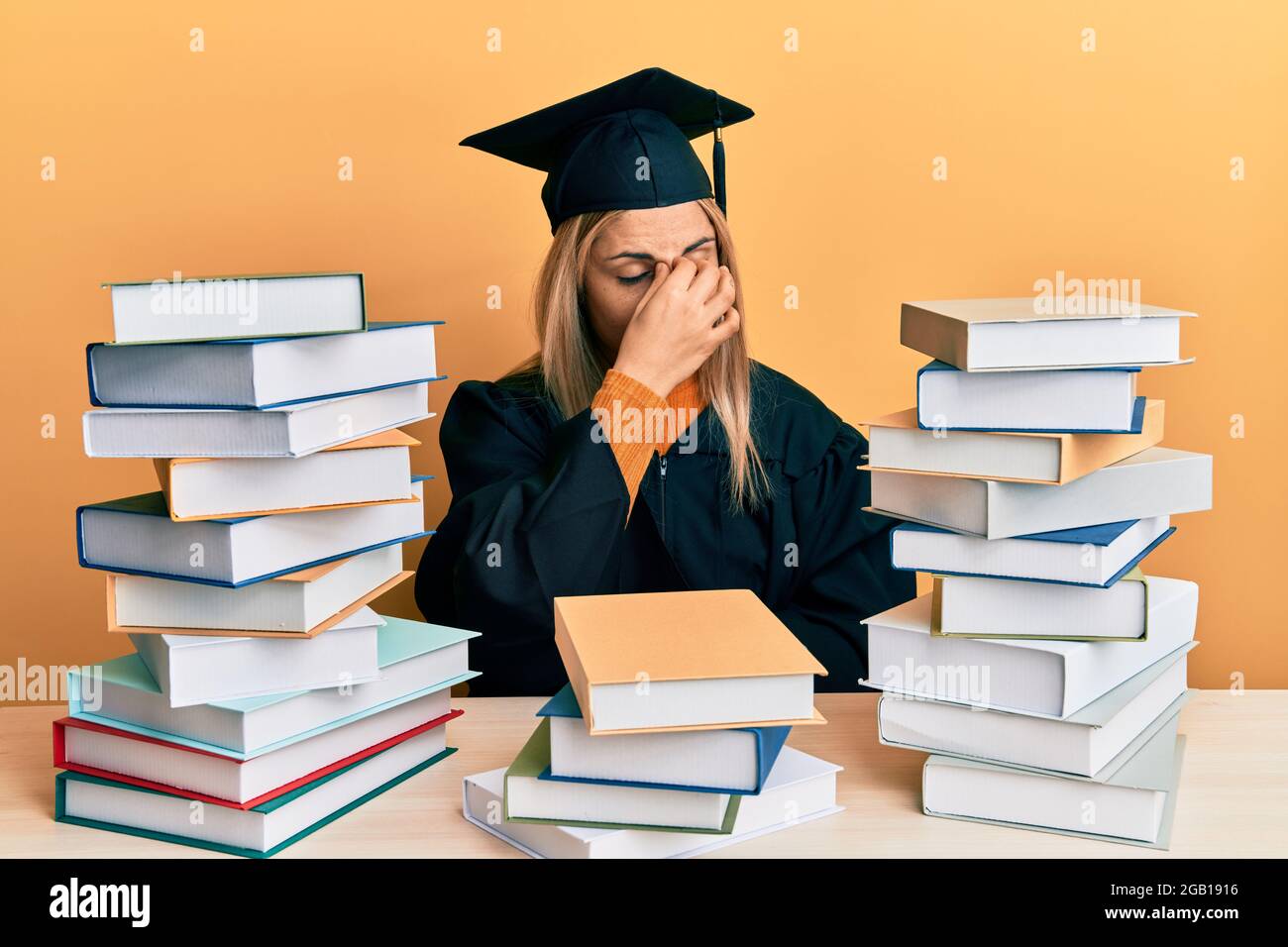 Young caucasian woman wearing graduation ceremony robe sitting on the ...