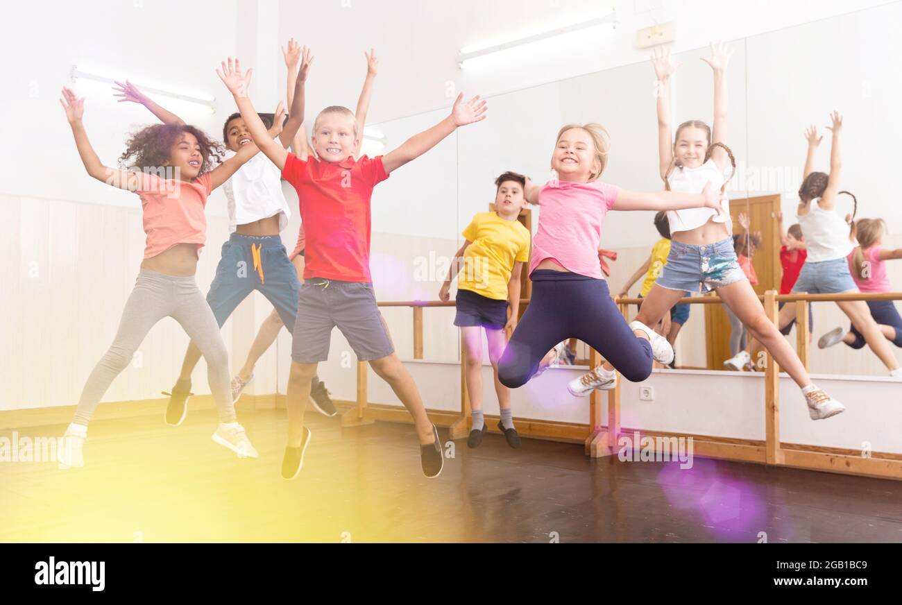 Happy sporty kids jumping together in dance studio Stock Photo - Alamy