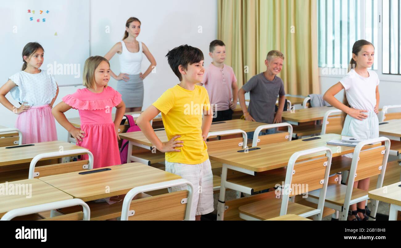 Small school kids doing physical exercises with teacher Stock Photo - Alamy