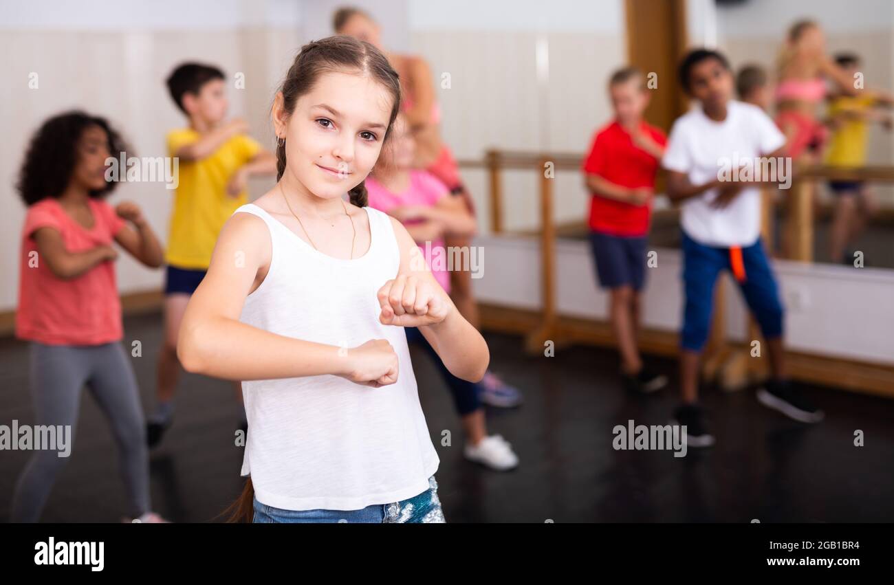 Tween girl training vigorous dance during group class Stock Photo - Alamy