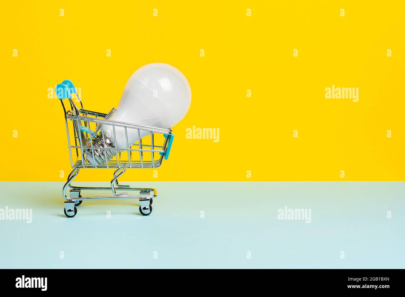Light bulb in the toy Shopping cart or trolley on bright yellow ...