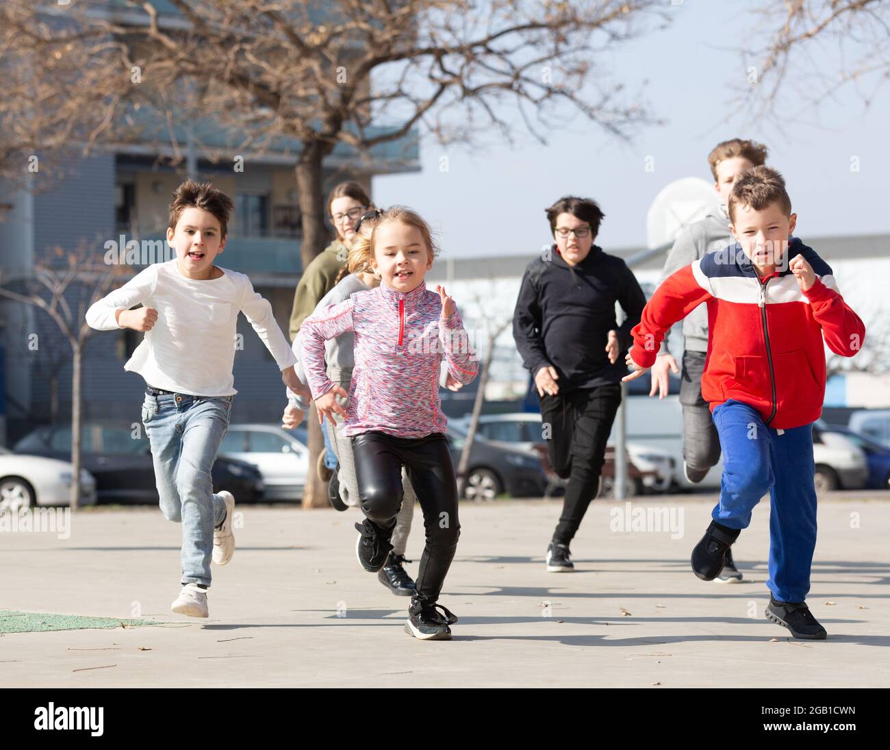 Group of joyful children running down the city street Stock Photo - Alamy