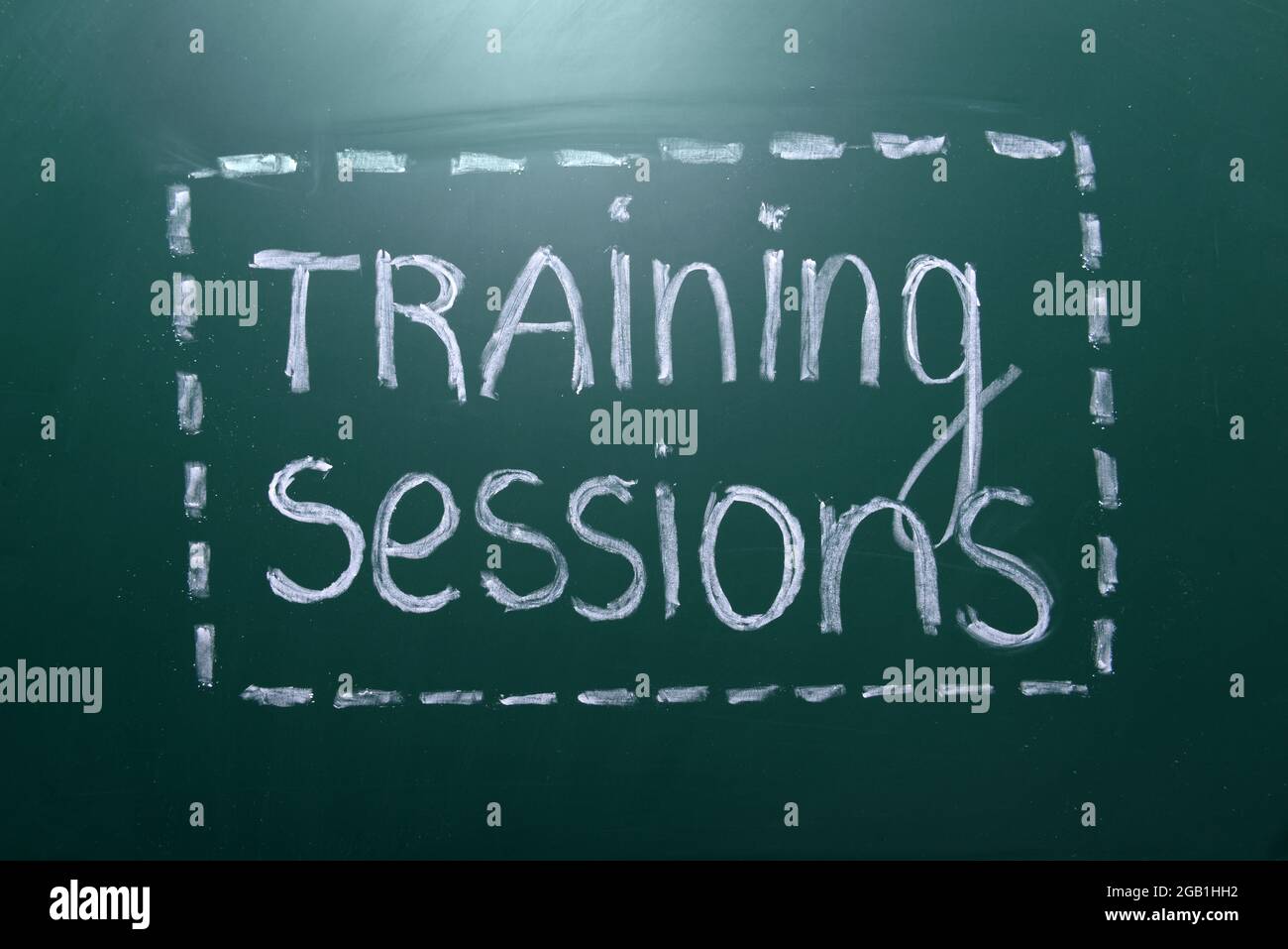 Training sessions inscription written with white chalk on blackboard ...