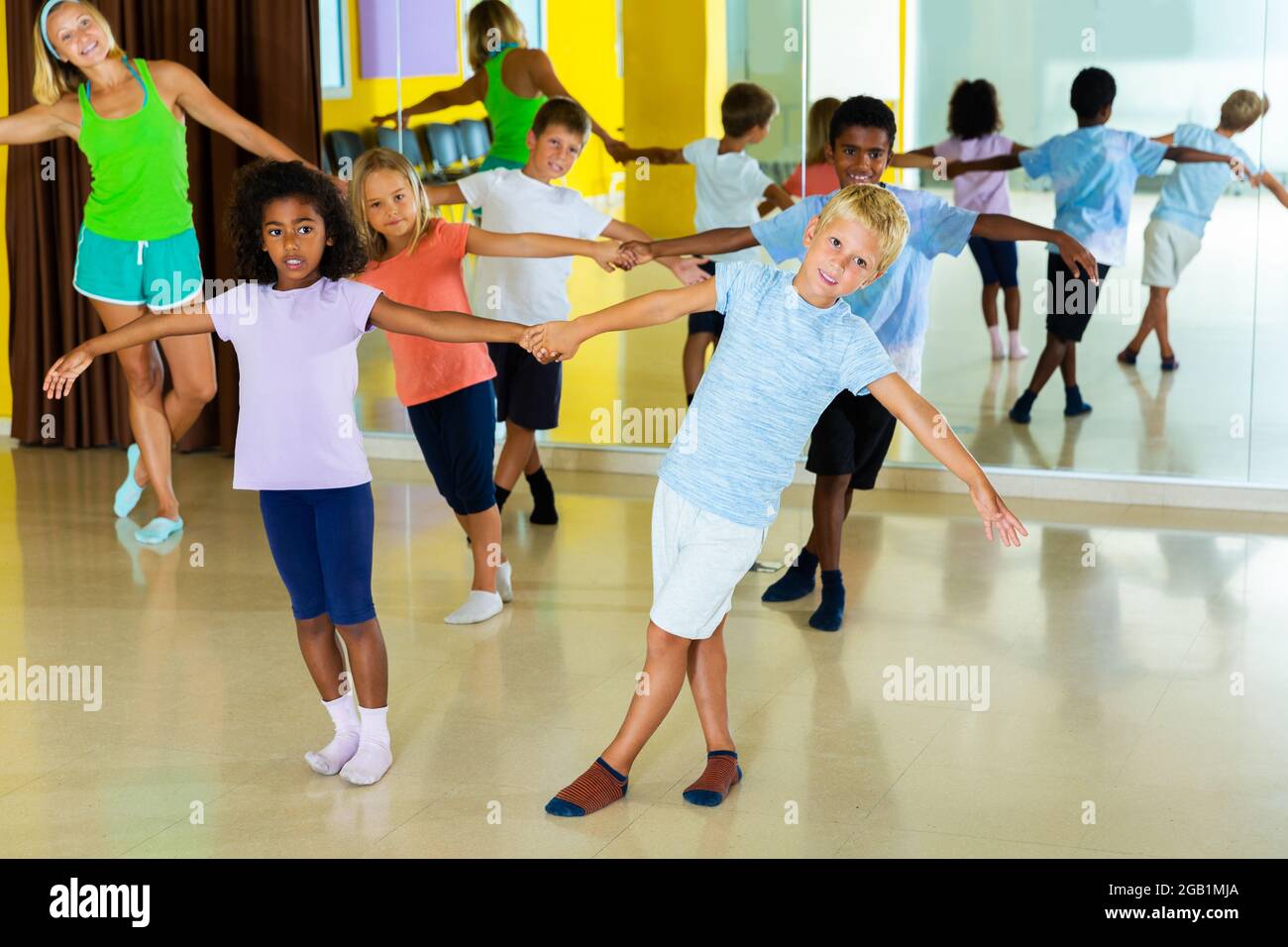 boys and girls dancing rock-and-roll in pairs with female trainer Stock ...