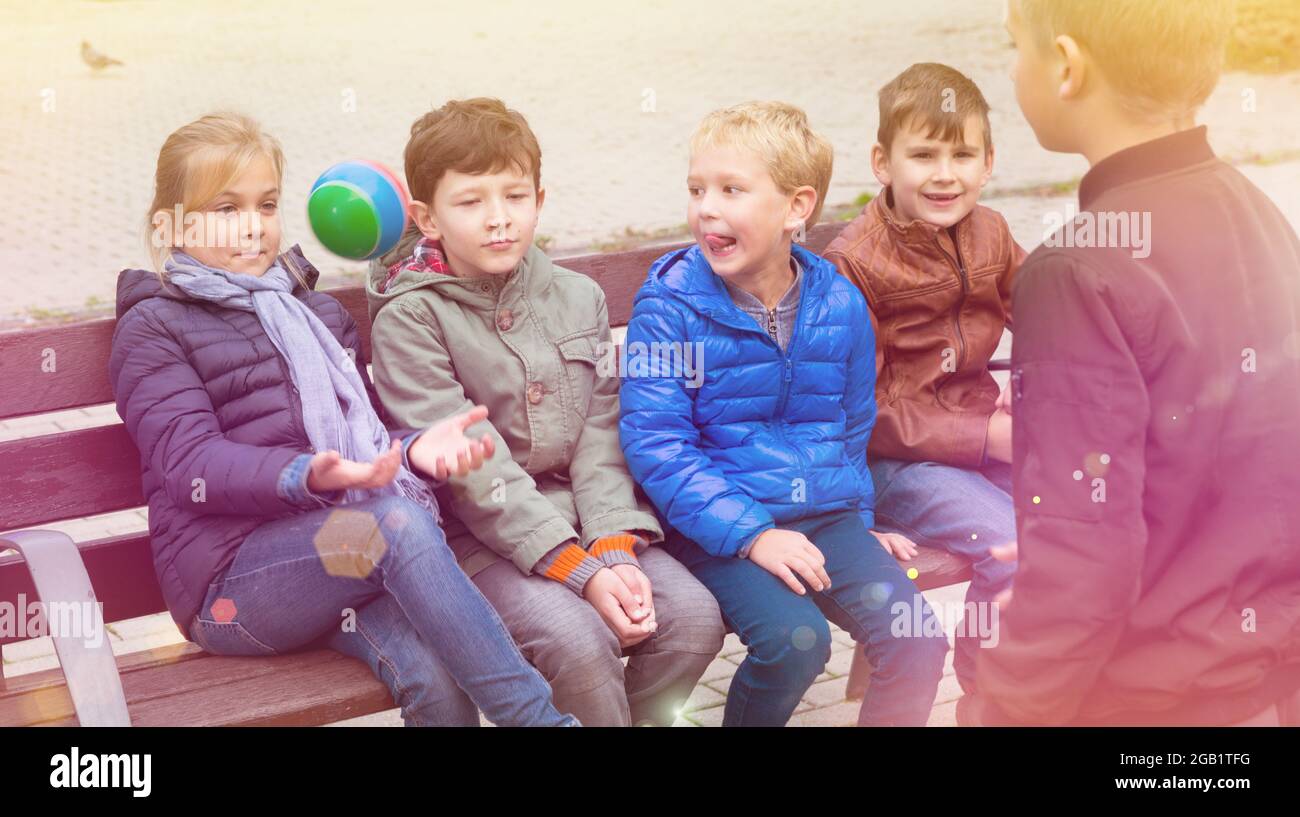 Children playing with ball on bench Stock Photo - Alamy