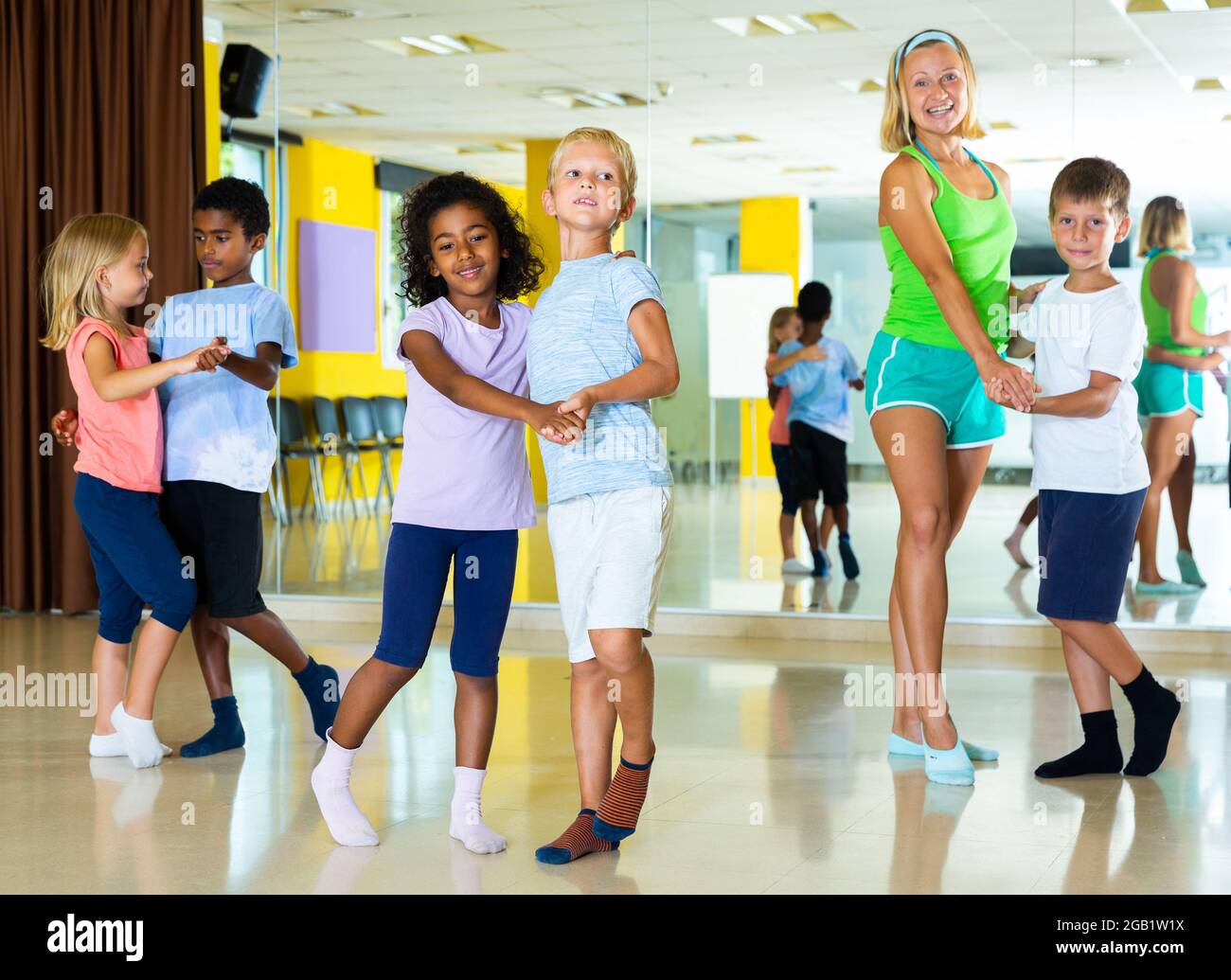 Positive little boys and girls dancing pair dance in the ballet studio ...