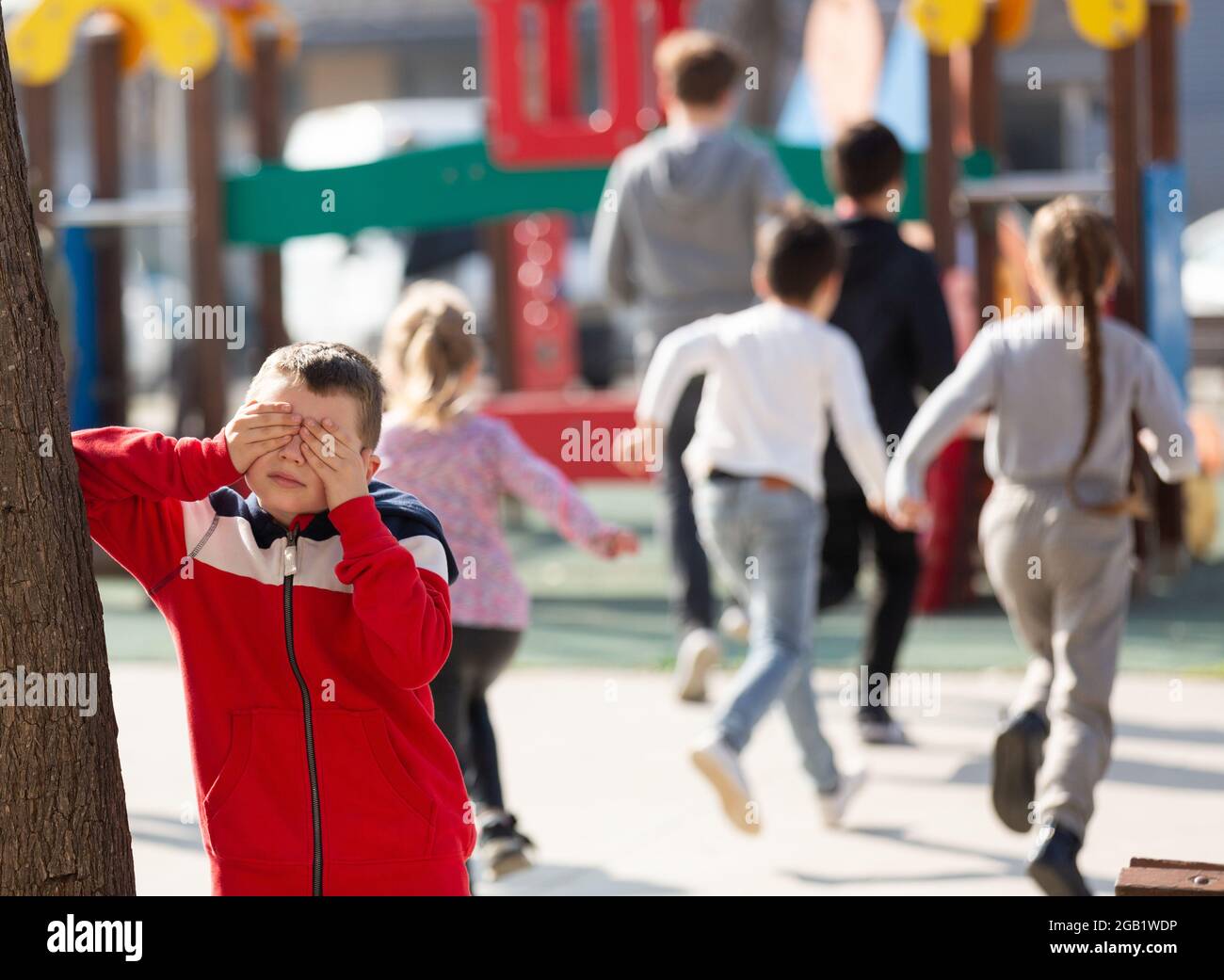 Boy playing hide and seek with friends Stock Photo - Alamy