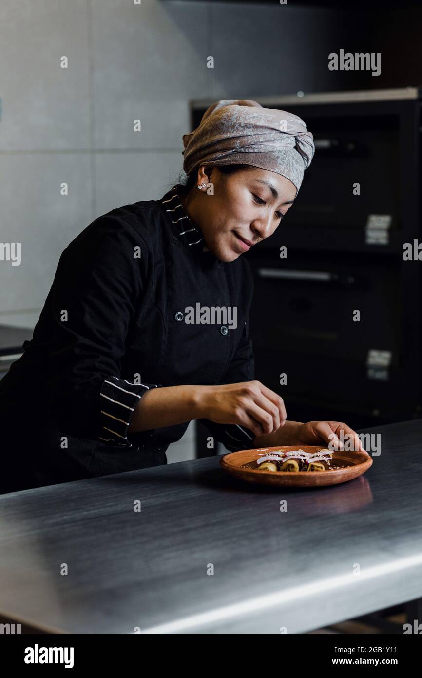 mexican woman cooking mole poblano enchiladas traditional food in a ...