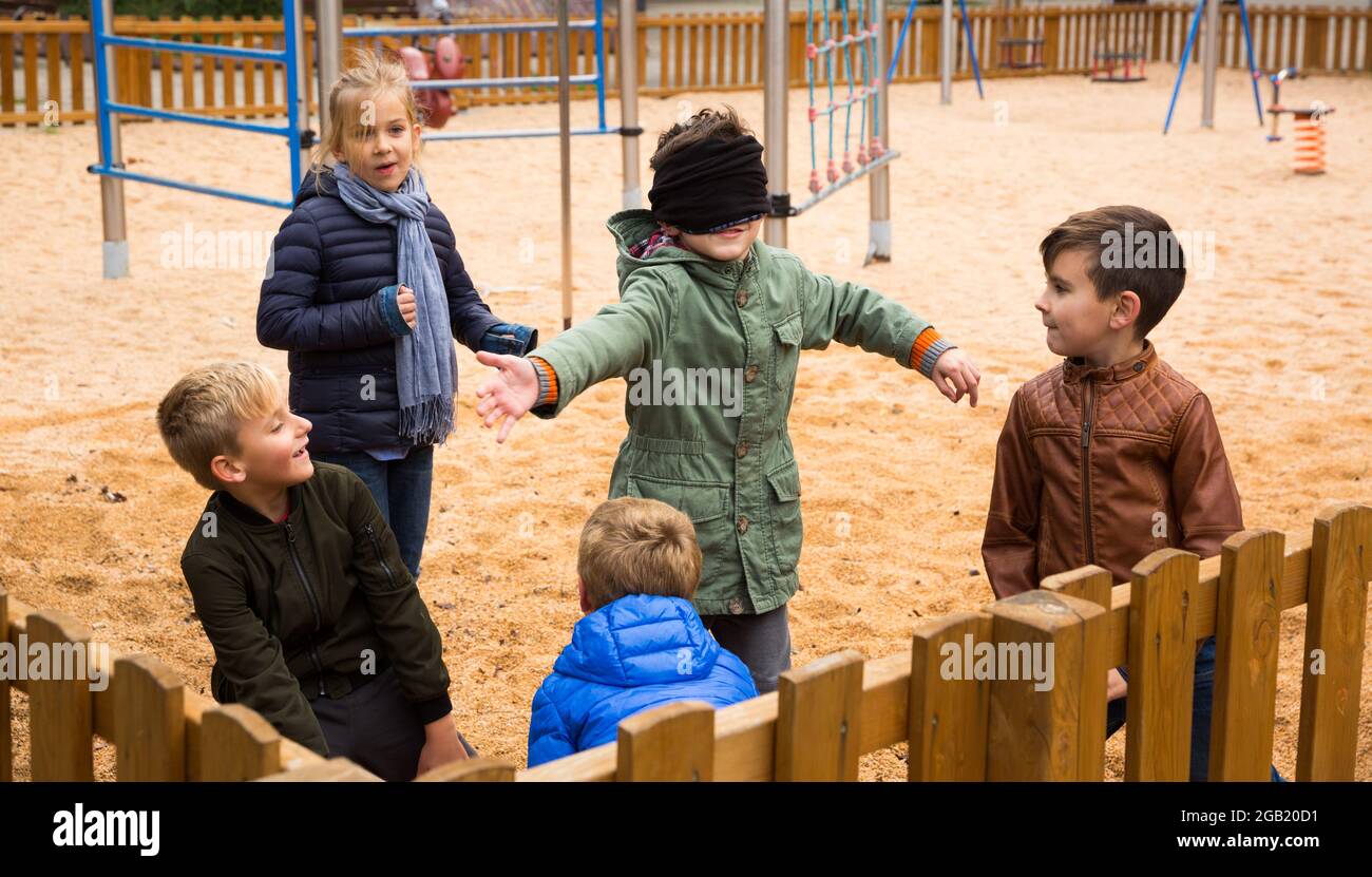 Happy kids playing blind man bluff Stock Photo - Alamy