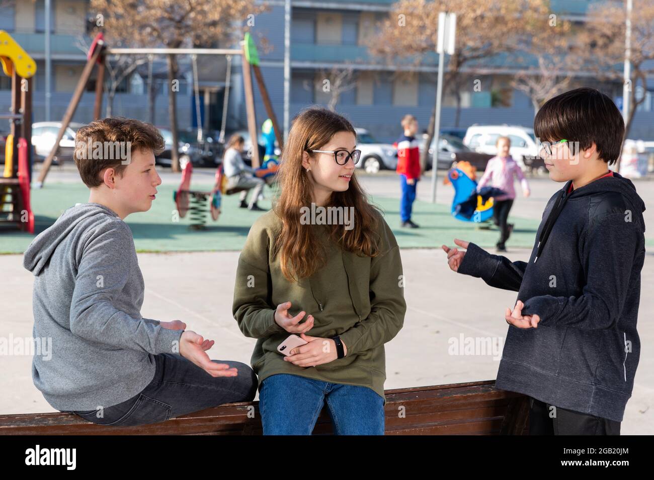 Children talking on bench on playground Stock Photo - Alamy
