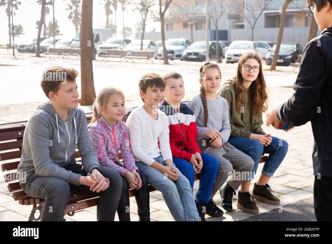 Children sitting on bench and playing ball Stock Photo - Alamy