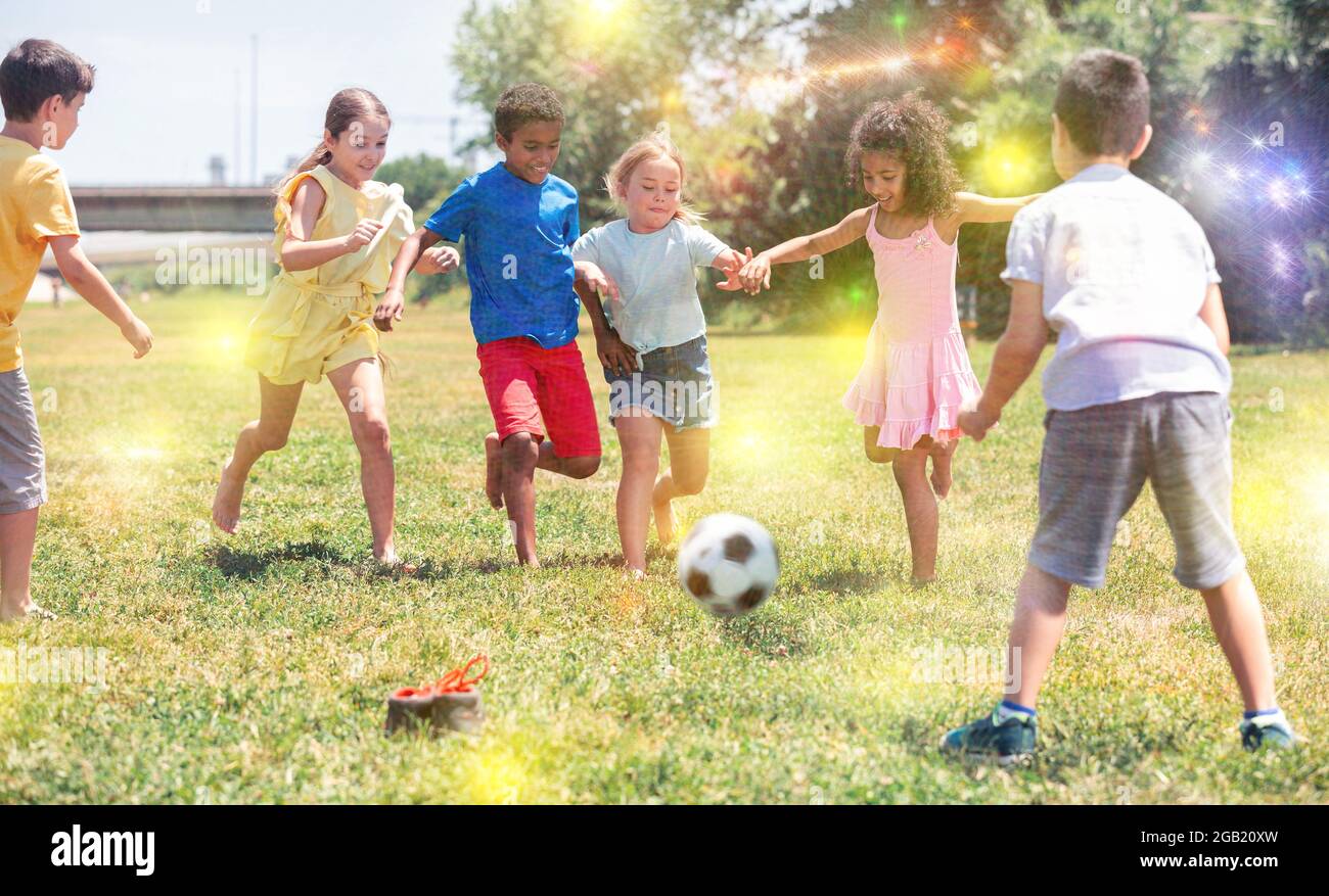 Group of happy schoolchildren playing football together Stock Photo - Alamy