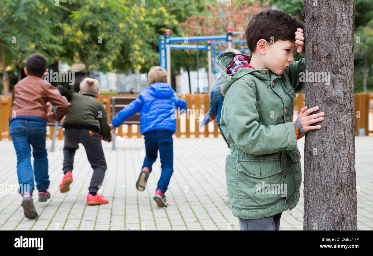 Boy playing hide and seek with friends Stock Photo - Alamy