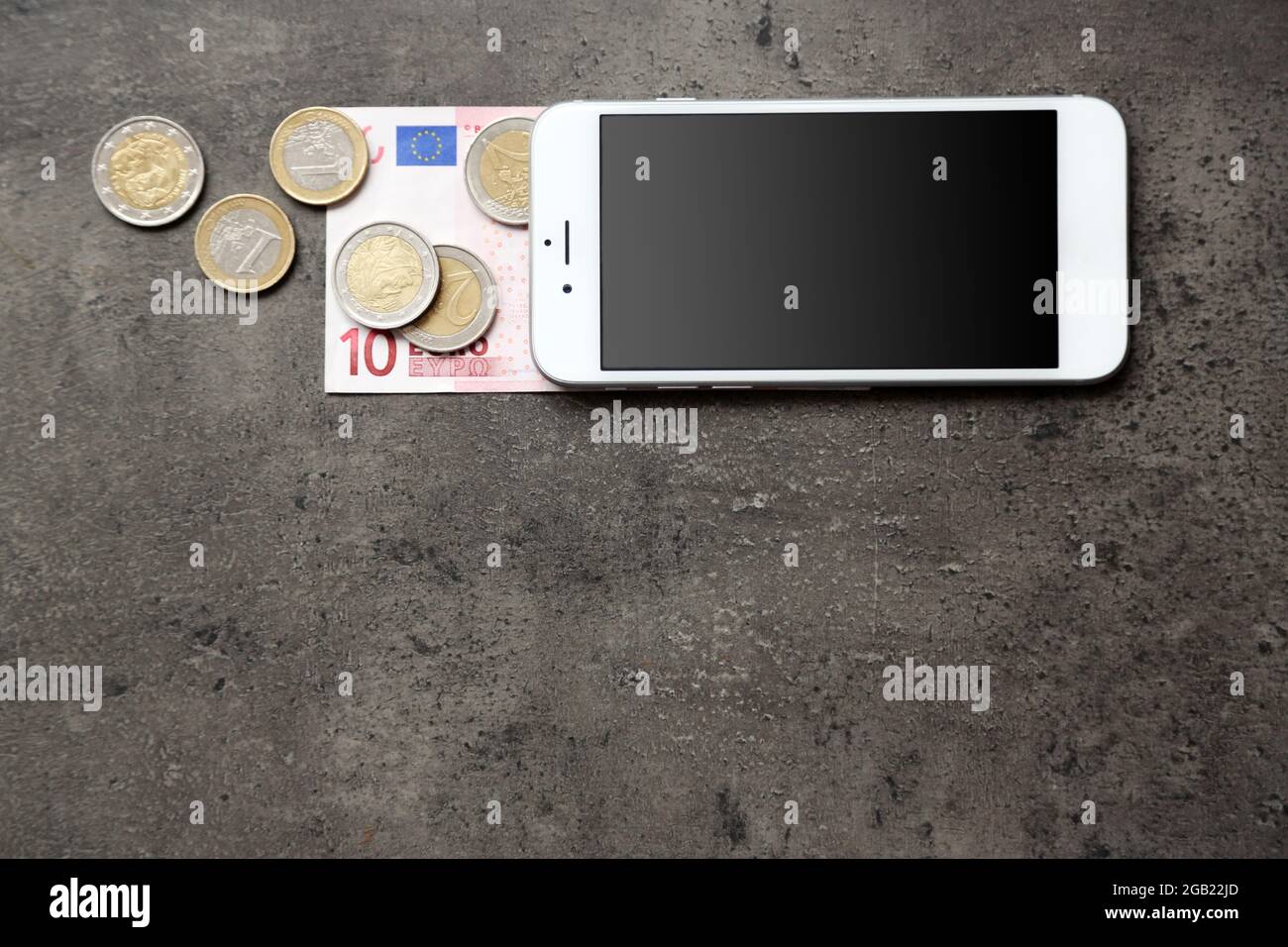 Smart phone with euro banknote and coins on grey background. Telephone ...