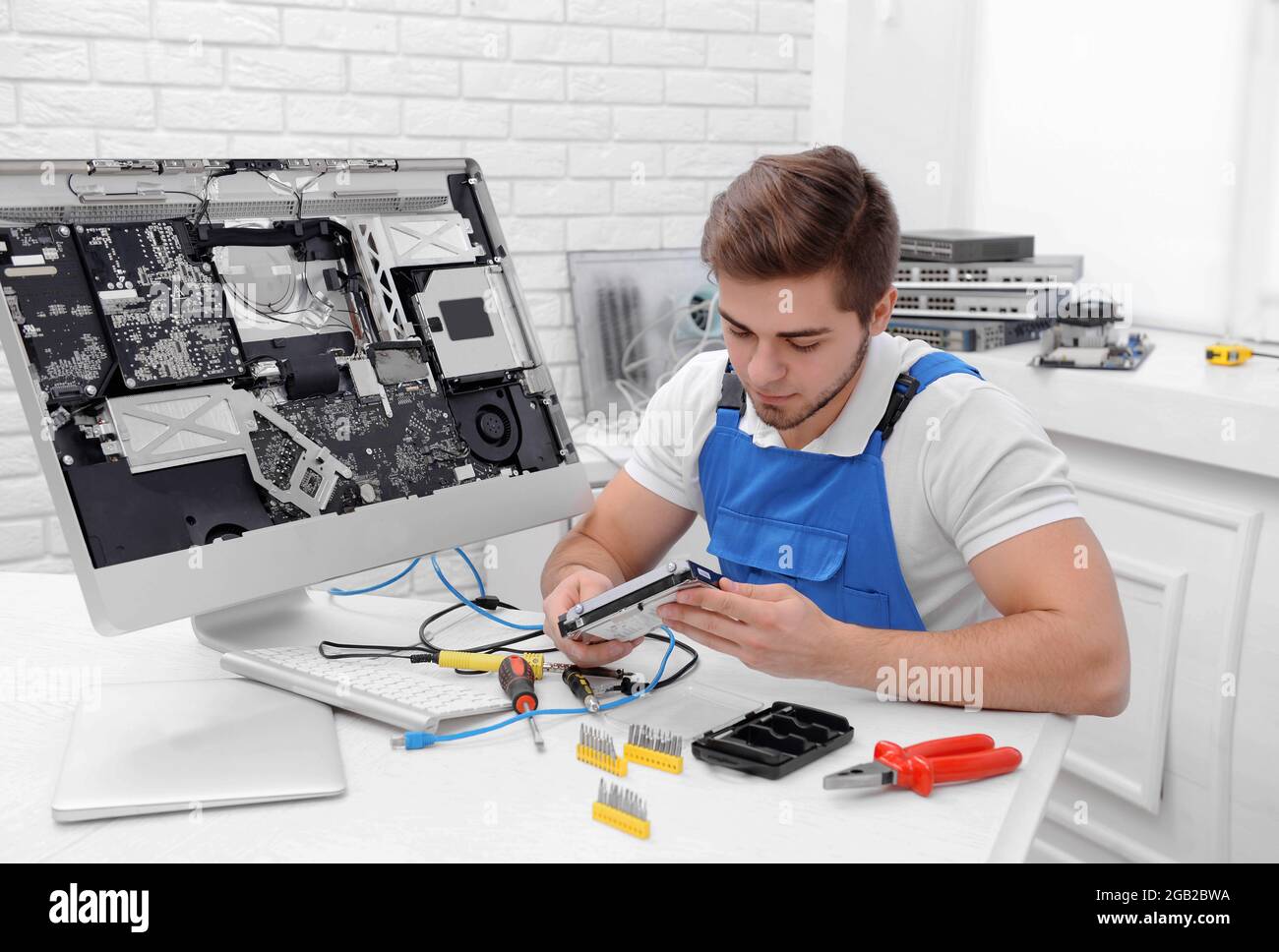Young repairer disassembling a computer internal parts in service ...