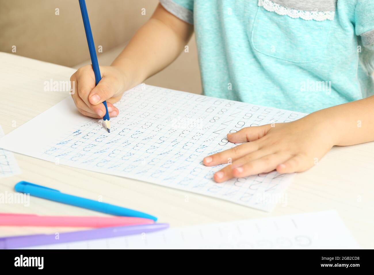 Schoolkid learns to write on sheet of paper, closeup Stock Photo - Alamy