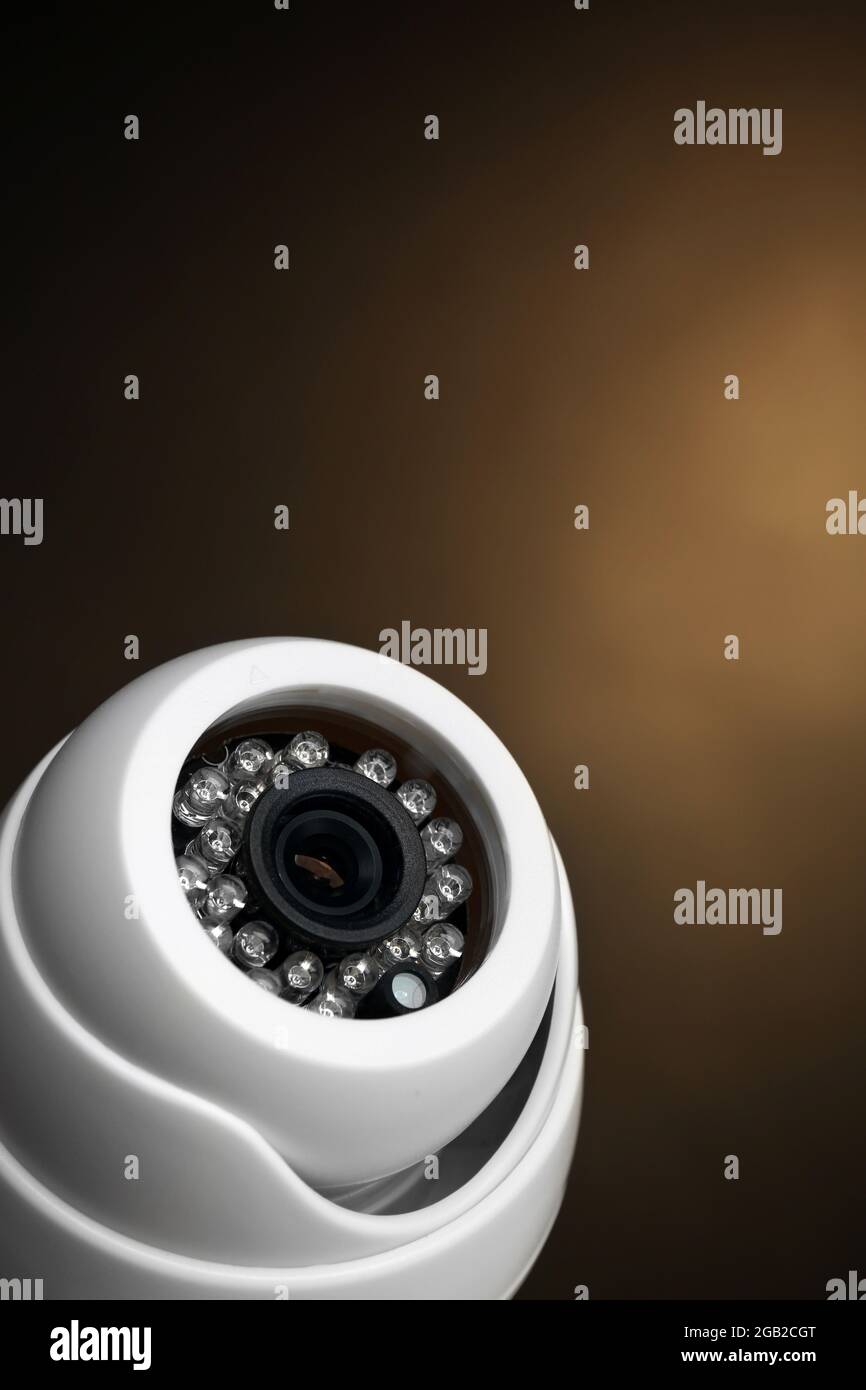 Security CCTV camera on dark yellow background, closeup Stock Photo - Alamy