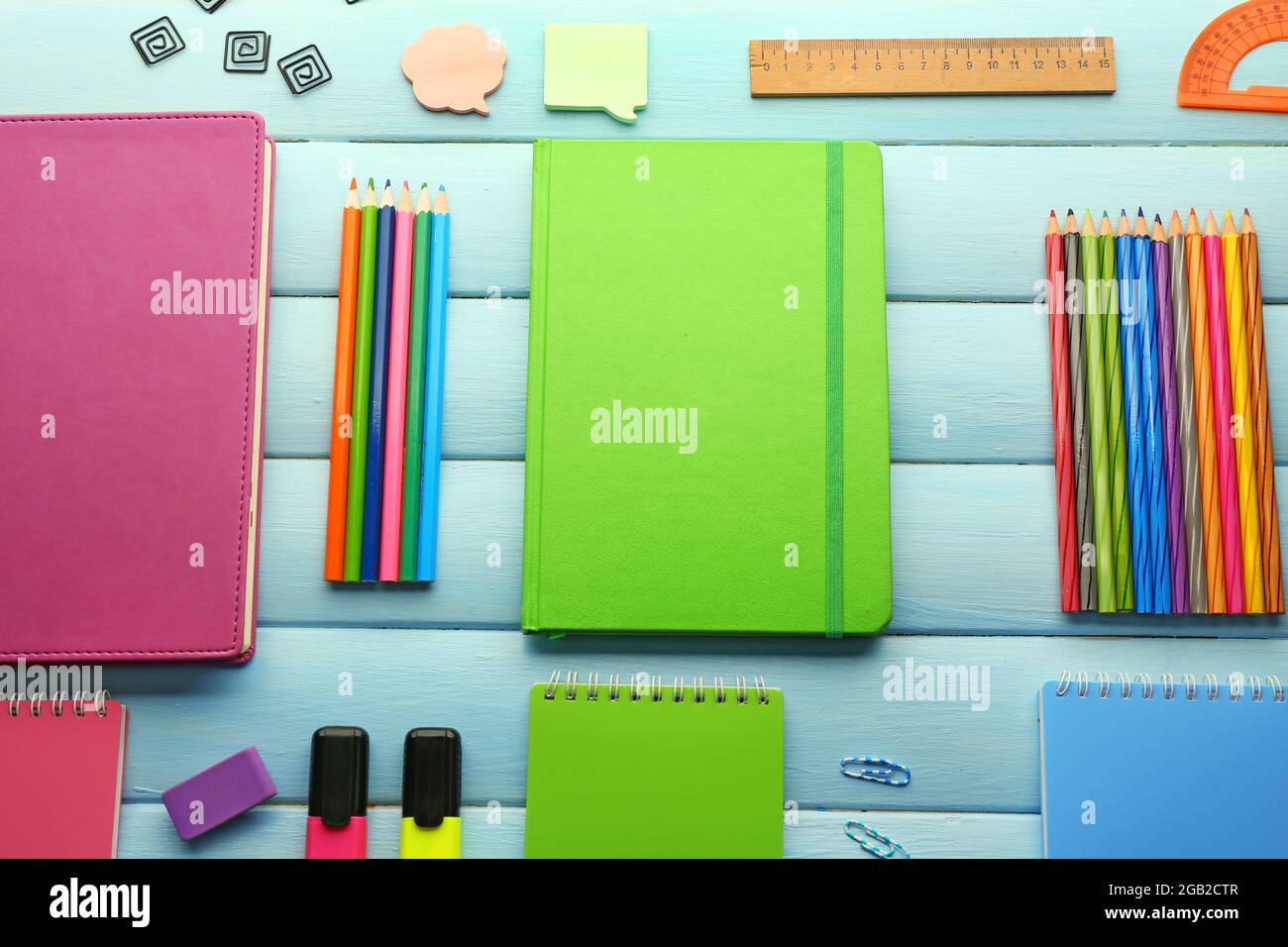 School set with notebooks and colored pencils on wooden blue background ...