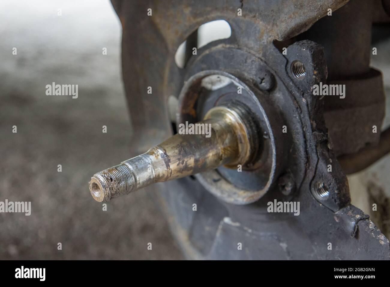 Exposed front axle of a hub in a car. Dirty and worn front axle of a ...