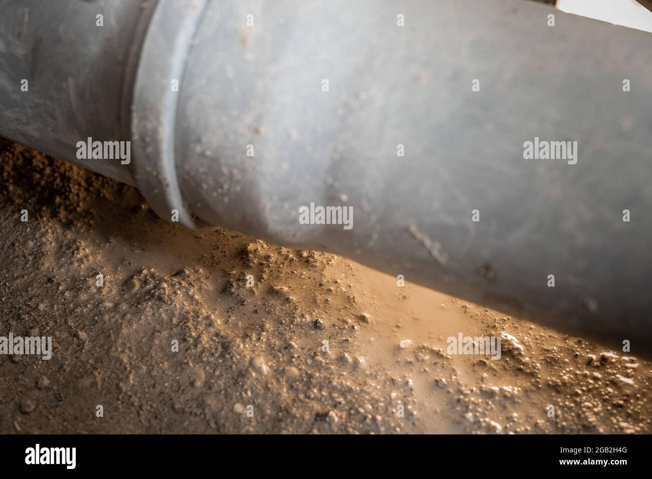 Leaking plastic sewage pipe in an old apartment, visible open hole with ...