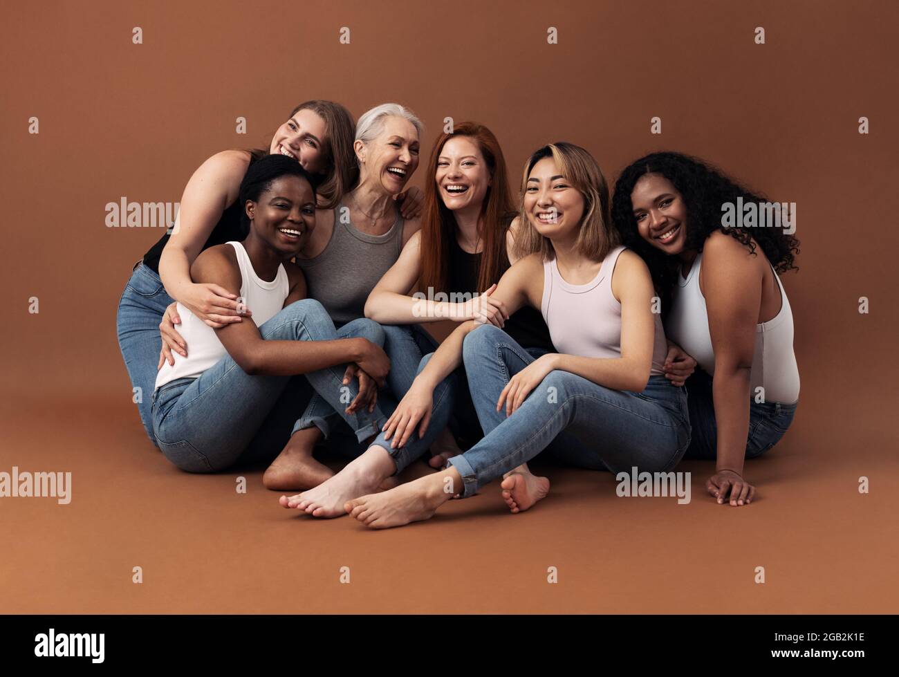 Portrait of six laughing women of different ages and body types sitting ...