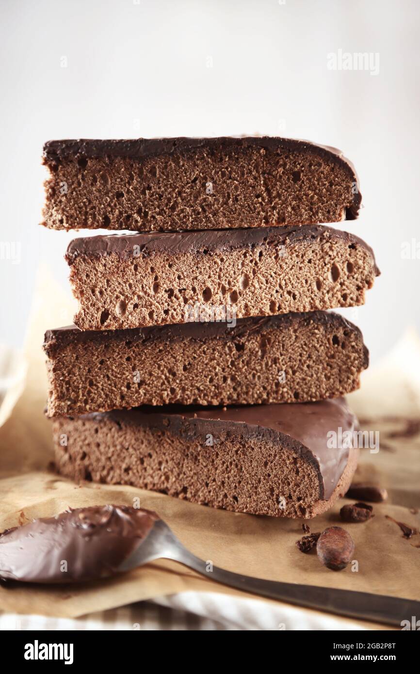 Pieces of frosting chocolate cake on parchment paper Stock Photo - Alamy